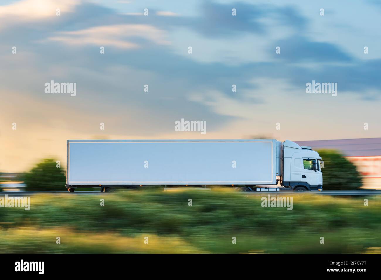 Truck with a refrigerated semi-trailer traveling fast on the highway ...