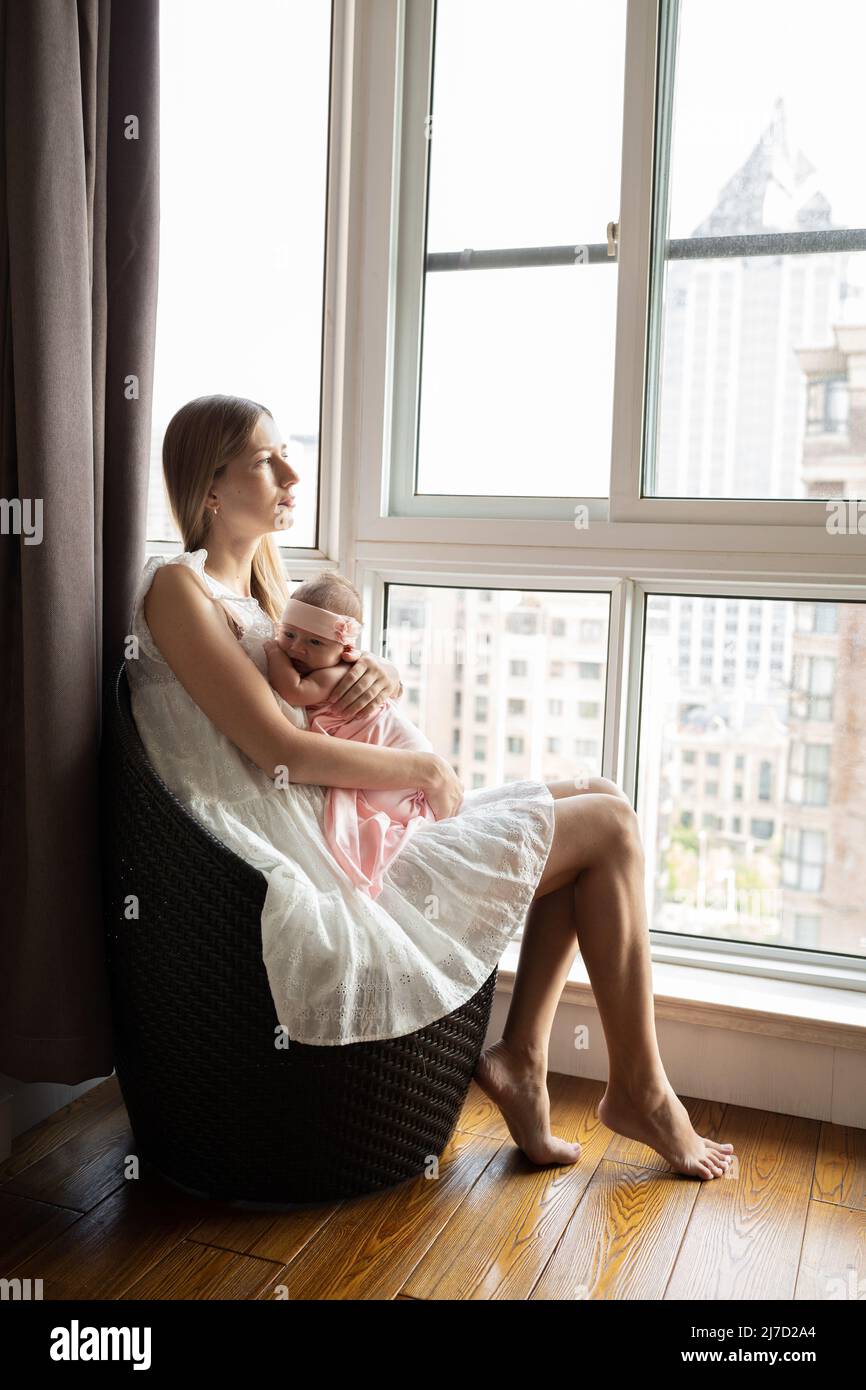 Portrait of young Caucasian mother holds hug little newborn baby two ...