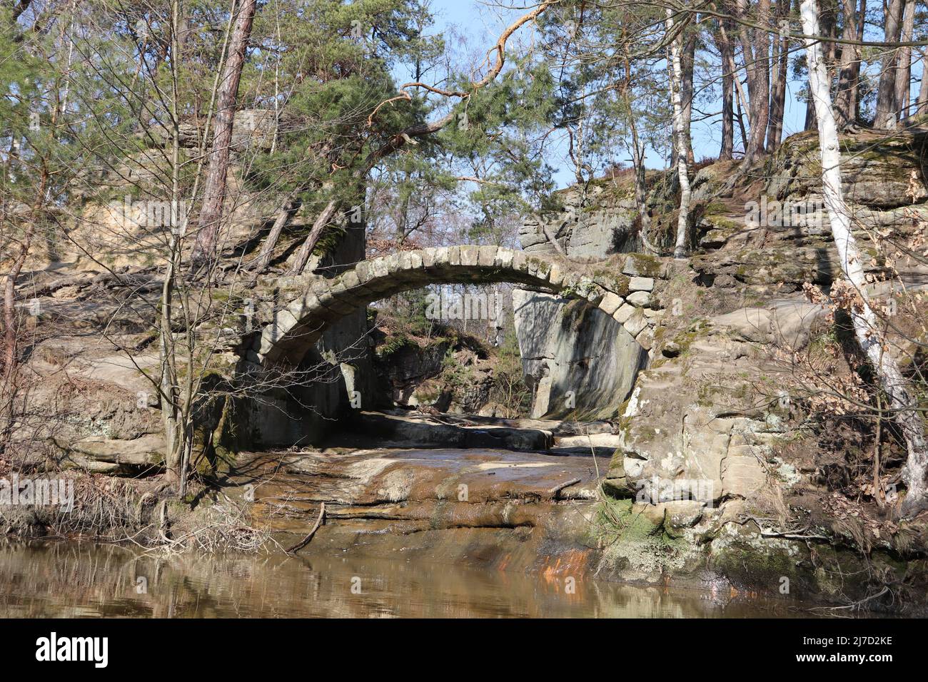 An ancient stone bridge spanning between two sandstone rocks between ...