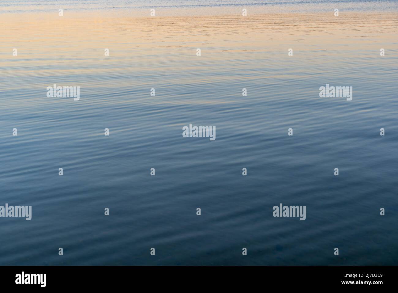 Abstract background of blue water on a lake. Texture of water waves and ...