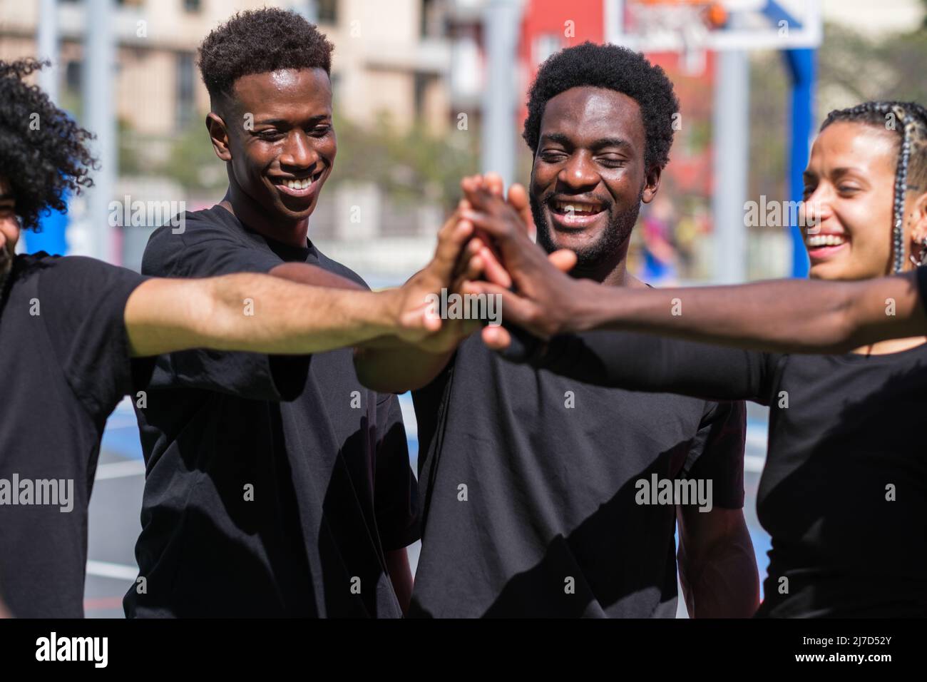 Group of young people joining hands to work together Stock Photo - Alamy