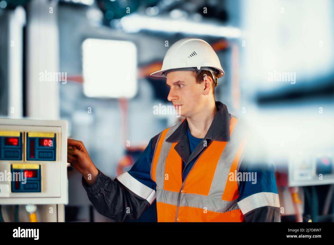 Operator or engineer in helmet and protective vest checks modern ...