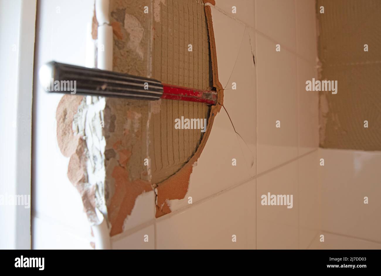 Breaking ceramic tiles, work in progress, maintenance Stock Photo - Alamy
