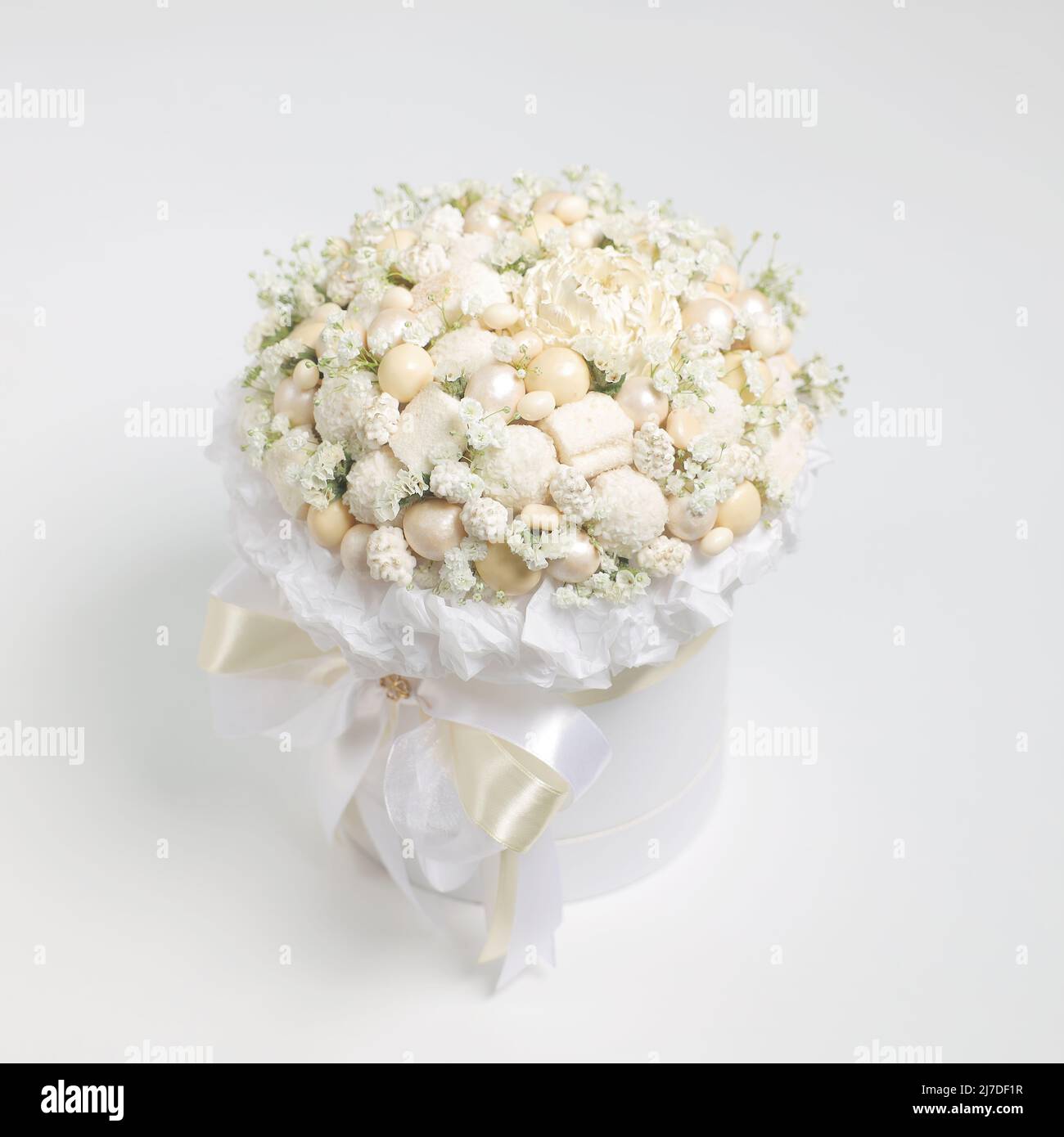White box filled with white chocolate sweets on a white background ...