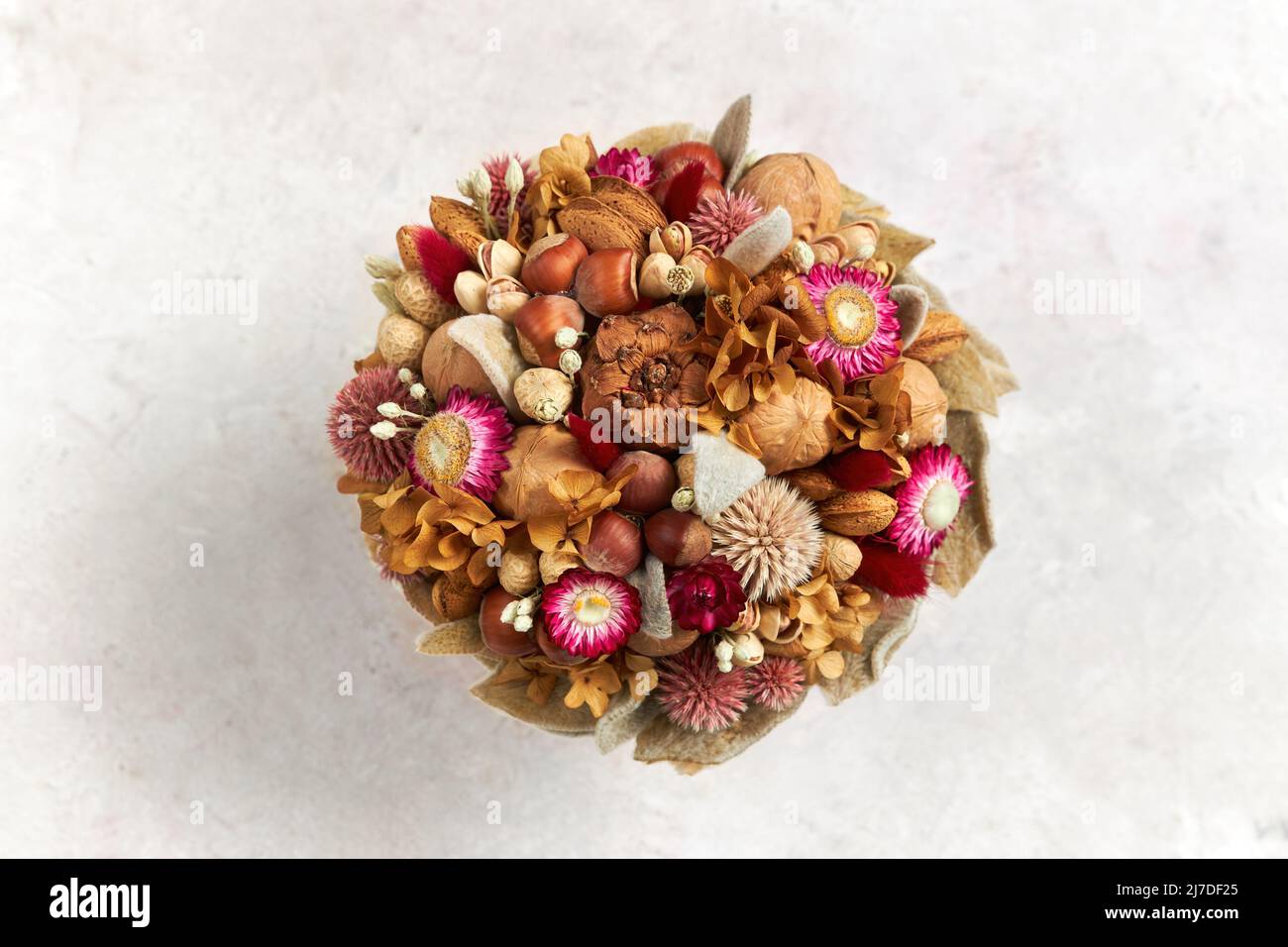 A small bouquet of dried flowers and nuts on a gray background. Top ...