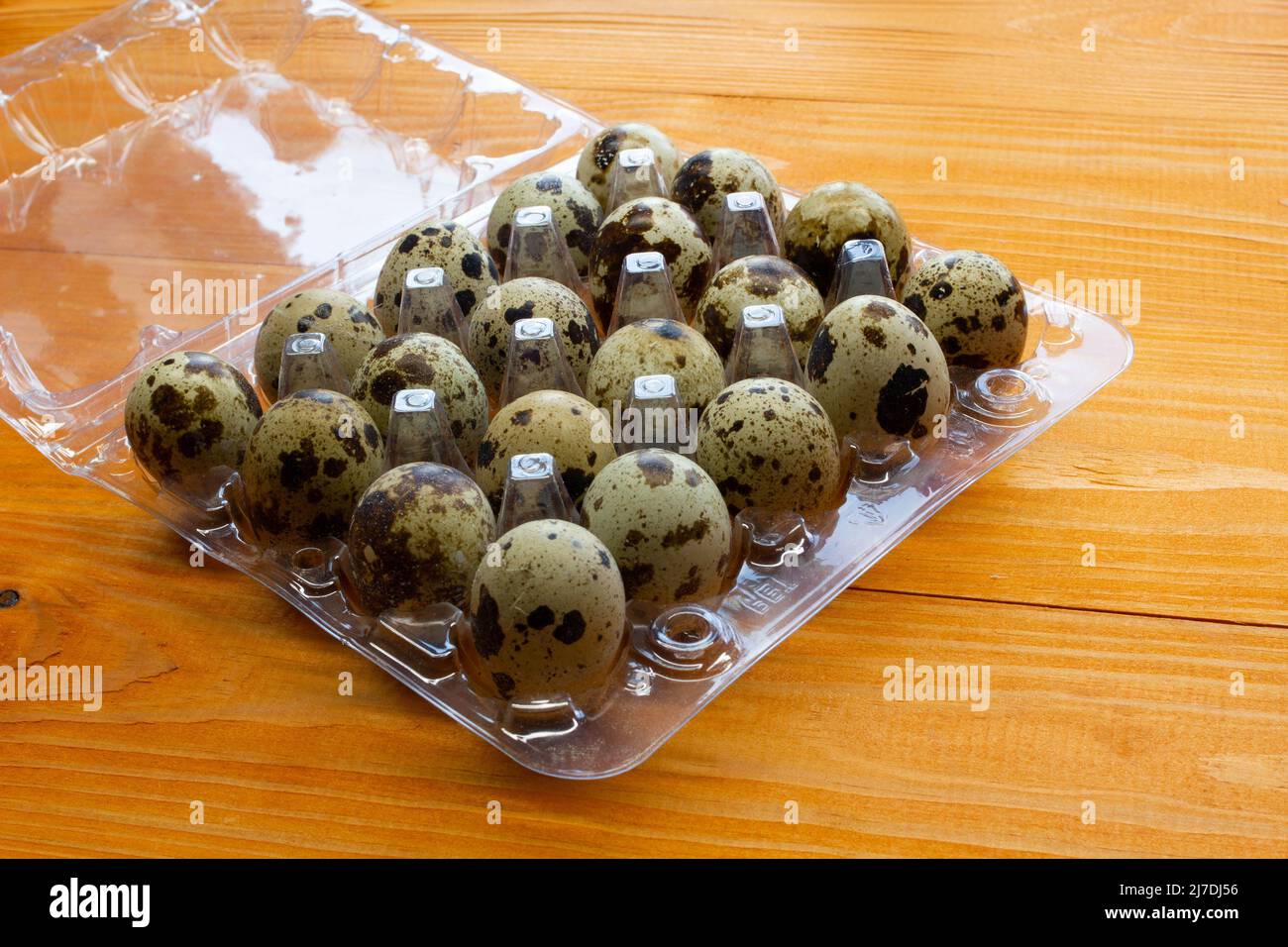 Quail eggs in a package on the table. Spotted quail eggs in a ...