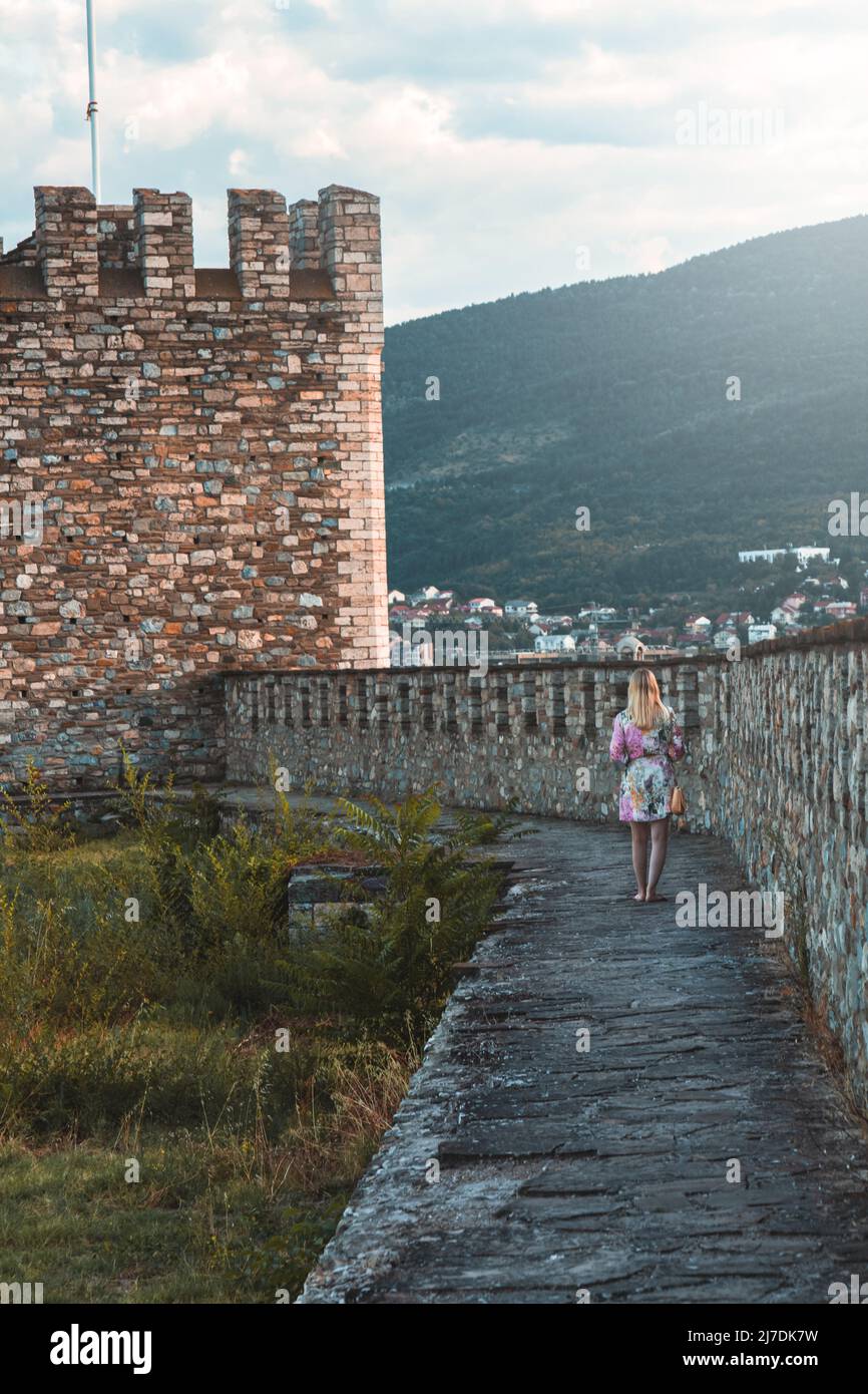 Girl walking along the Skopje fortress walls at golden hour sunset ...