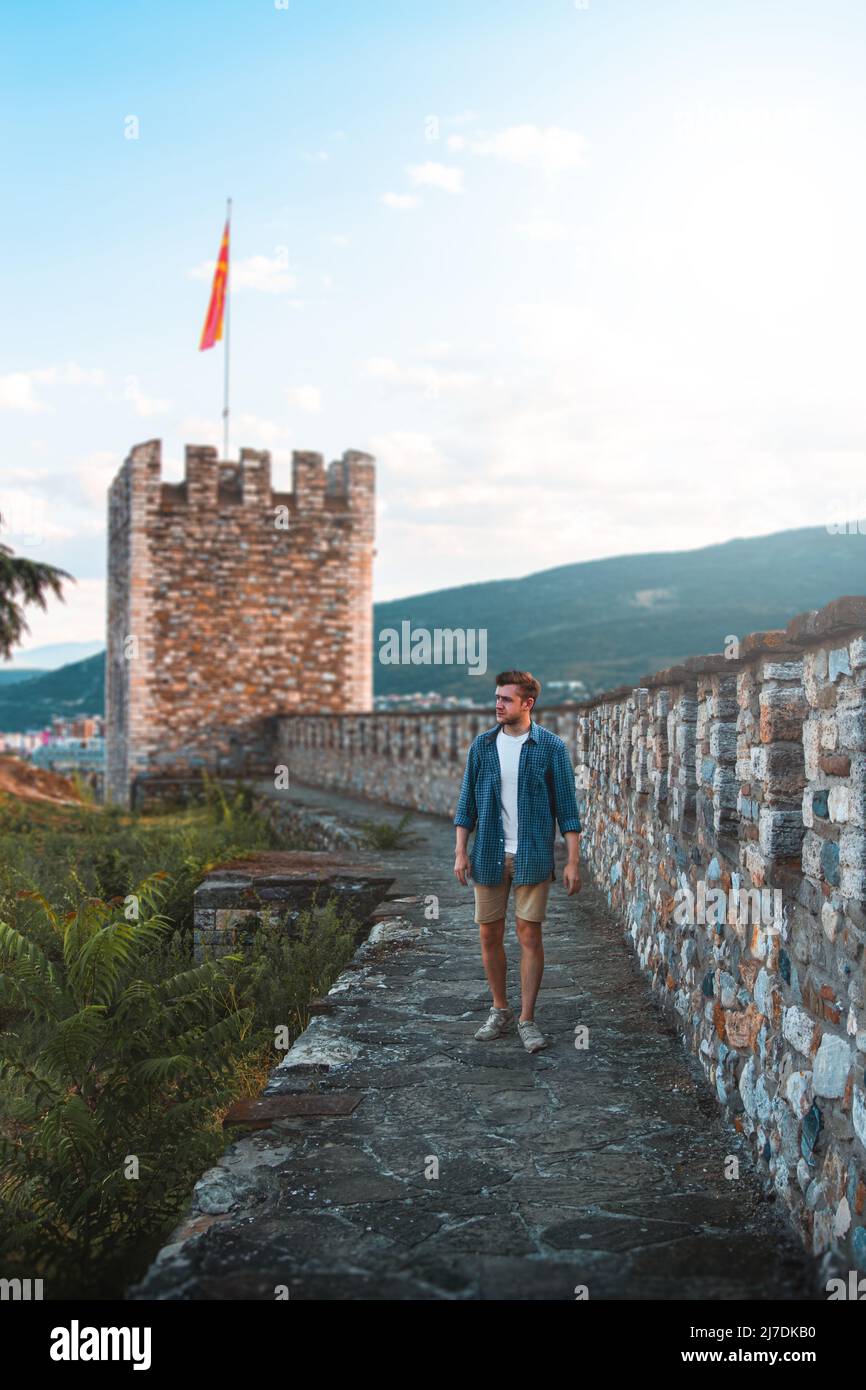 Man walking along the Skopje fortress walls at golden hour sunset ...