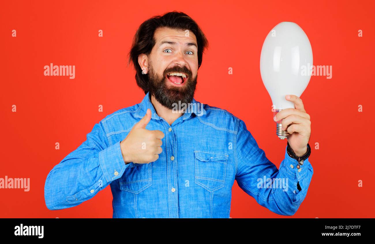 Good idea. Happy bearded man with light bulb shows thumb up. Male with ...