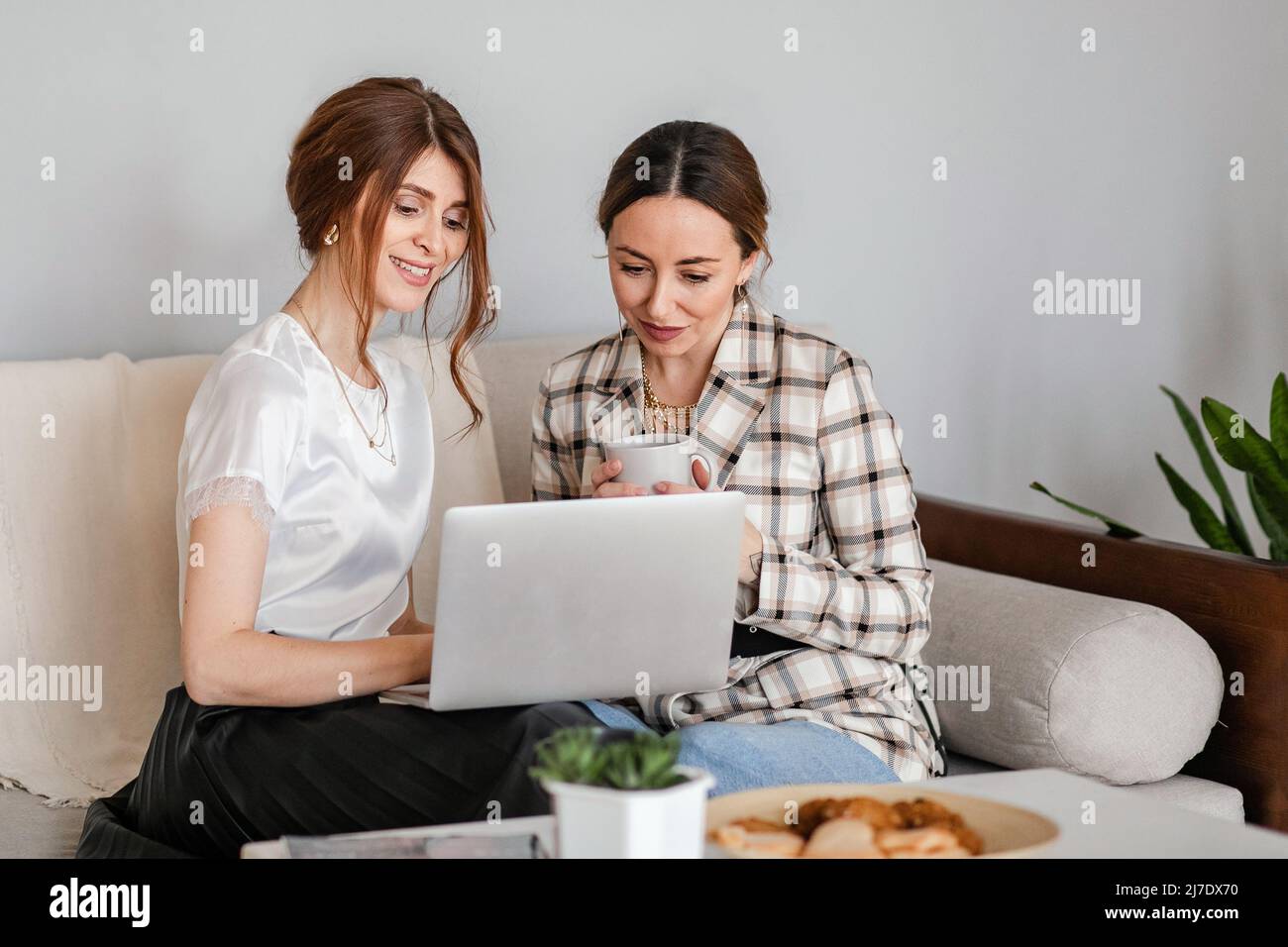 One-on-one meeting.Two young business women sit at a Desk in the office ...
