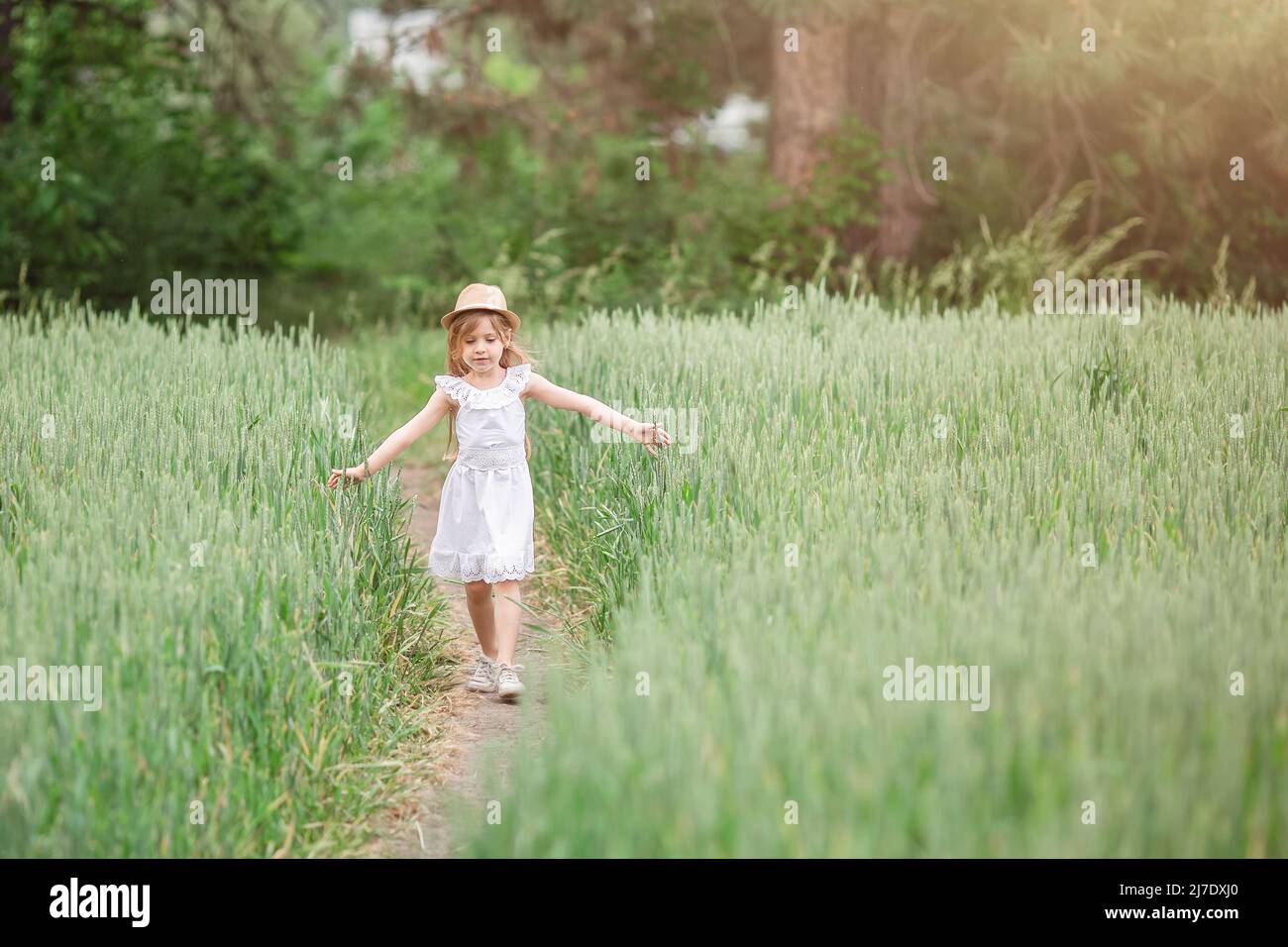 Portrait little girl blonde on at sunset in field. Little girl running ...