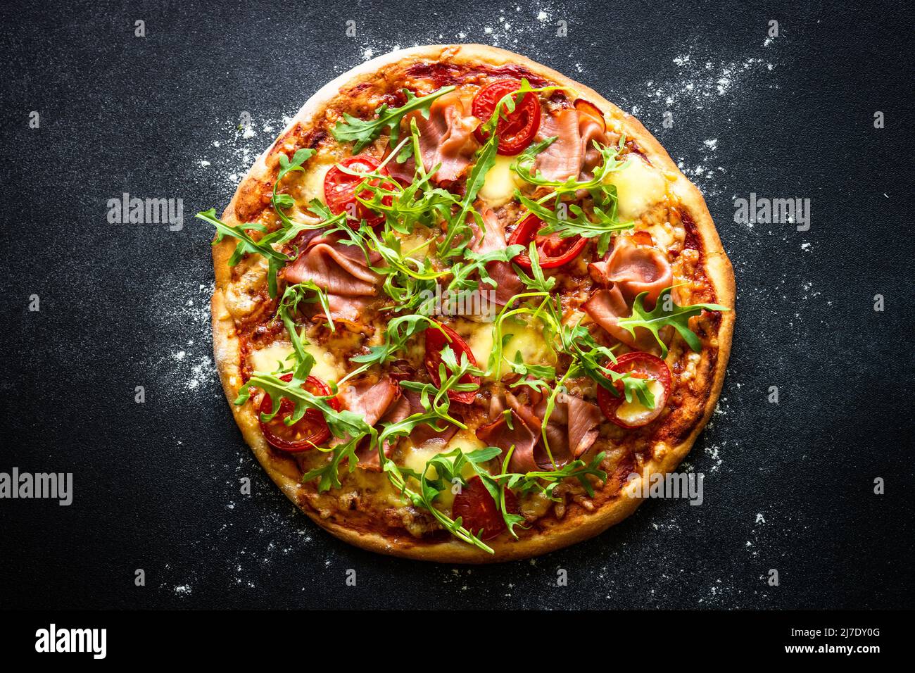 Traditional italian pizza with ham, cheese, tomatoes and arugula Stock ...