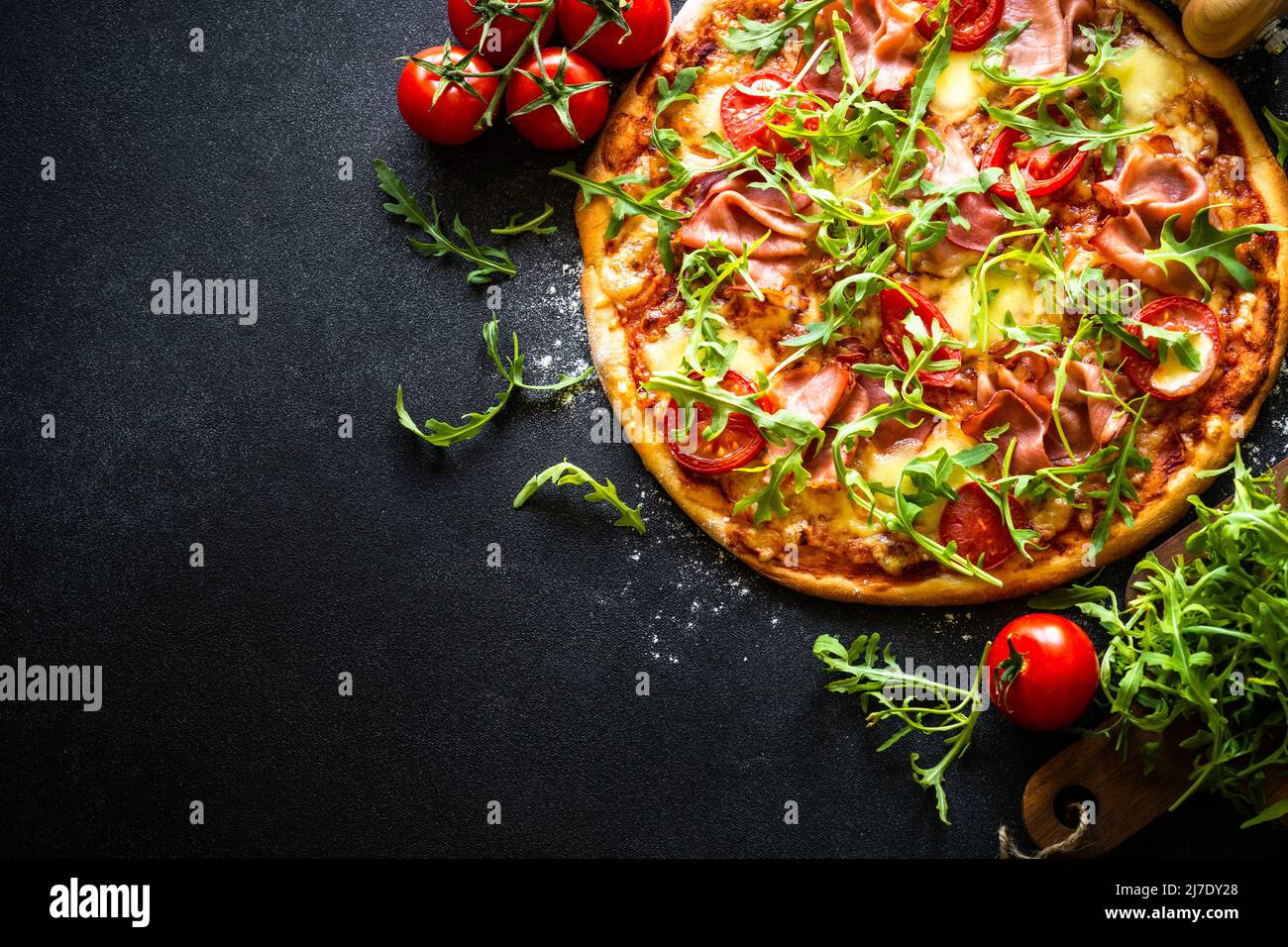 Traditional italian pizza with ham, cheese, tomatoes and arugula Stock ...