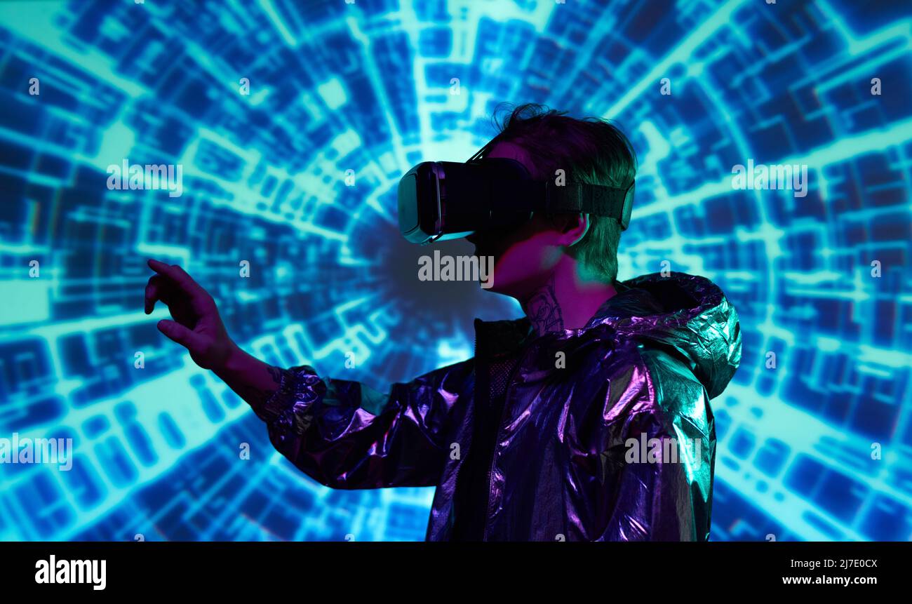 Side view of modern man in VR simulator pointing with finger while ...