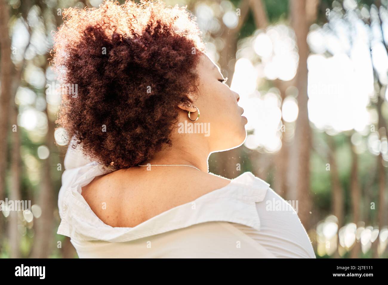 young curly african american woman looking back over her shoulder in a ...