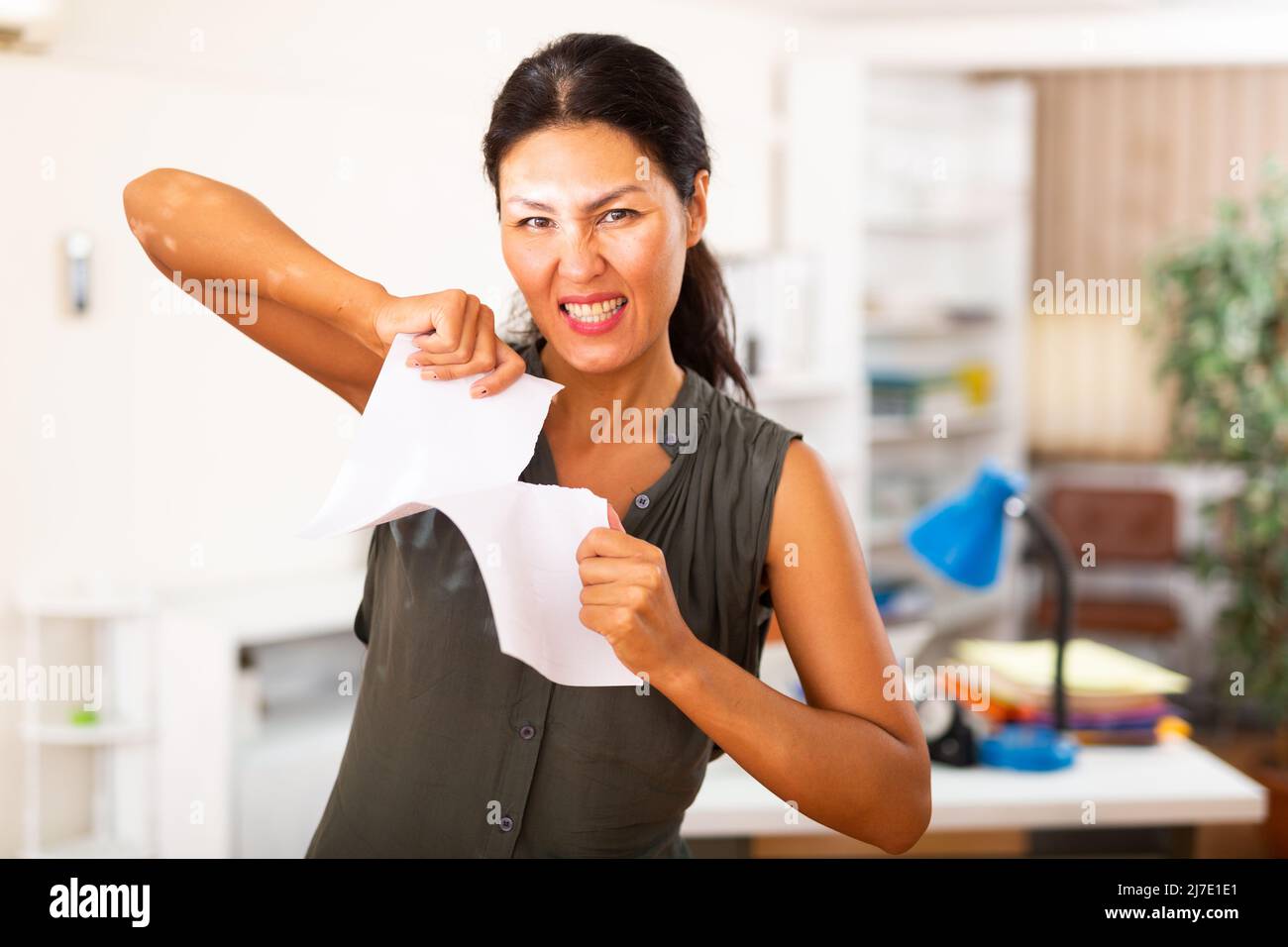 Desperate aggressive business woman ripping paper documents in office ...
