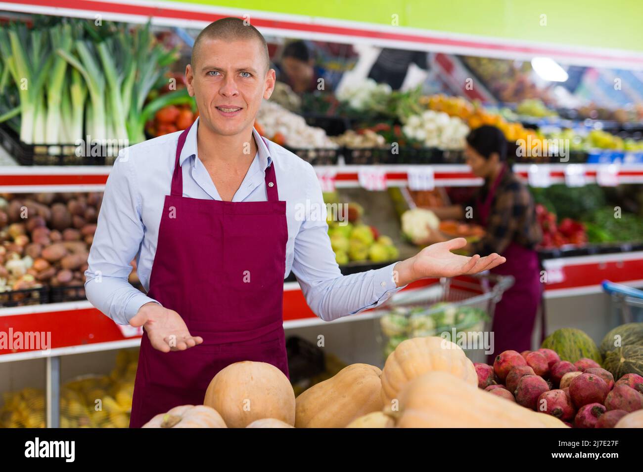 Successful salesman inviting to fruit and vegetable store Stock Photo ...