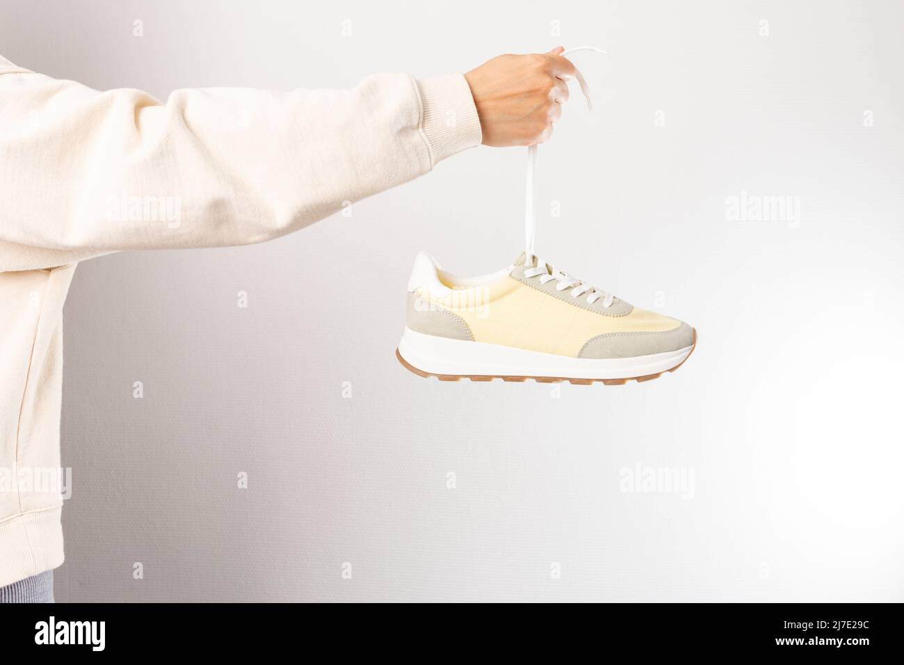 classic light color sneakers on grey background Stock Photo - Alamy