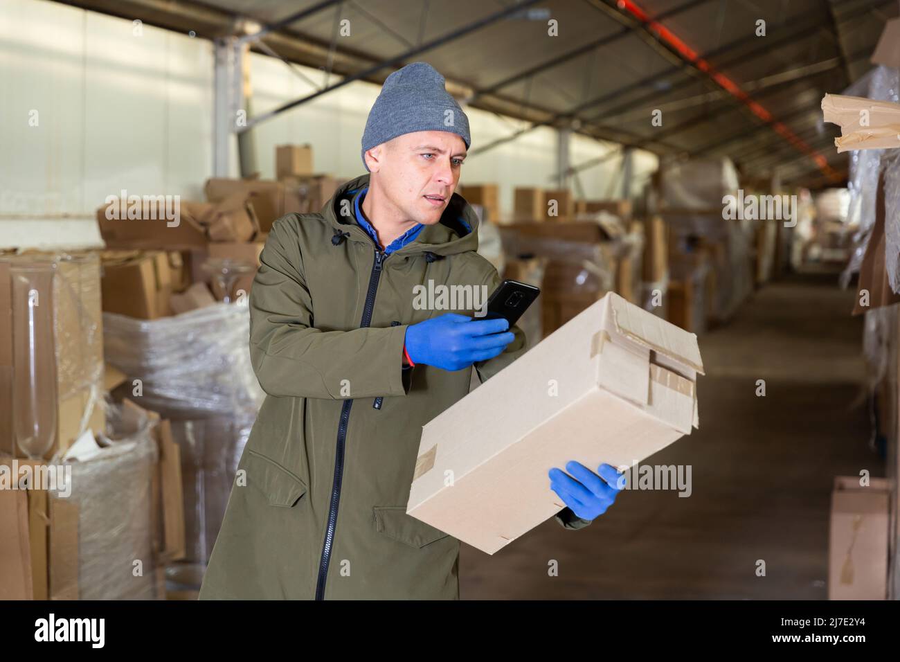 Store worker scans qr code on boxes using smartphone in warehouse shop ... Store worker scans qr code on boxes using smartphone in warehouse shop ...