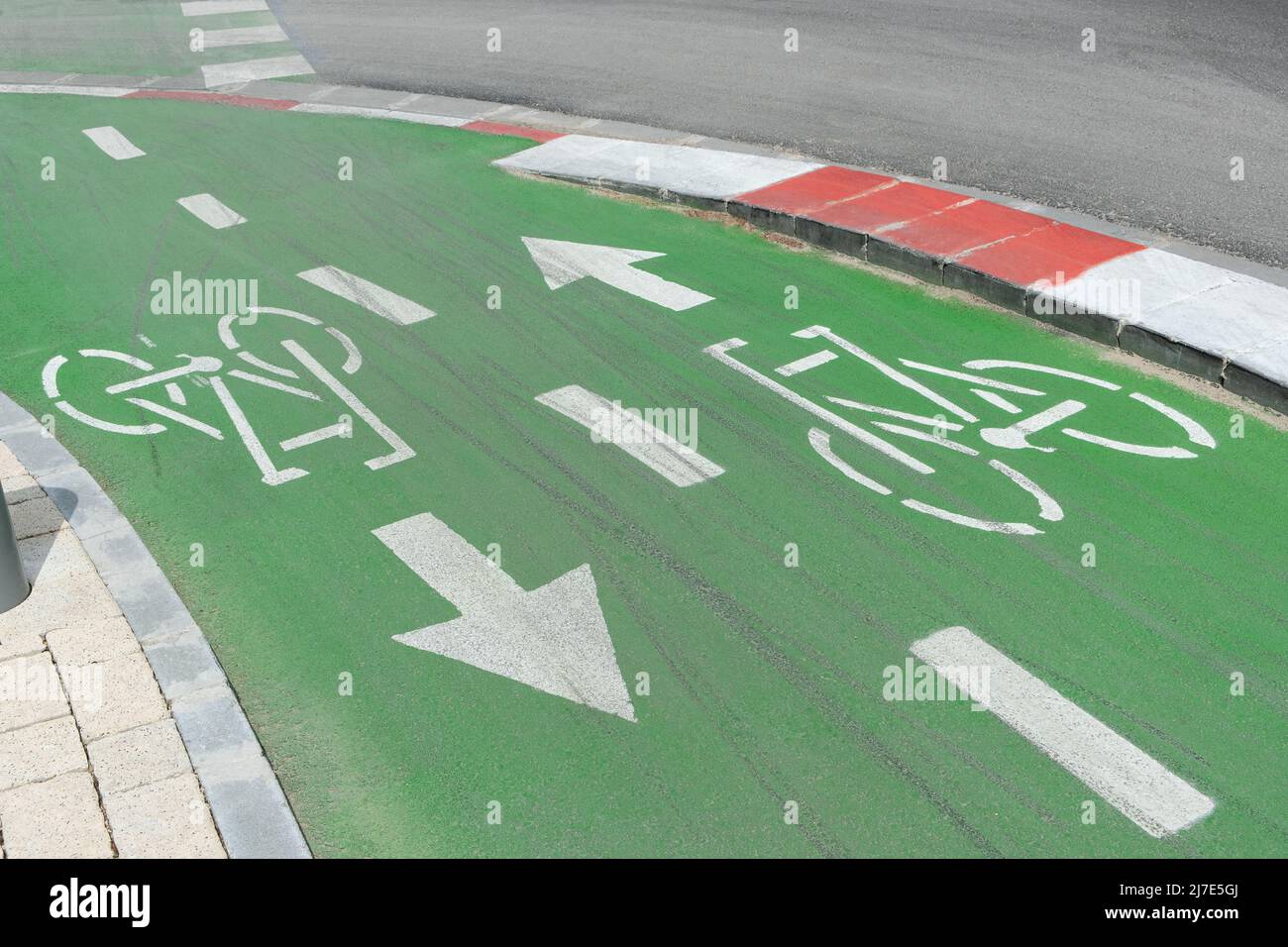 Bicycle sign painted on road surface. Green painted bike lanes in ...
