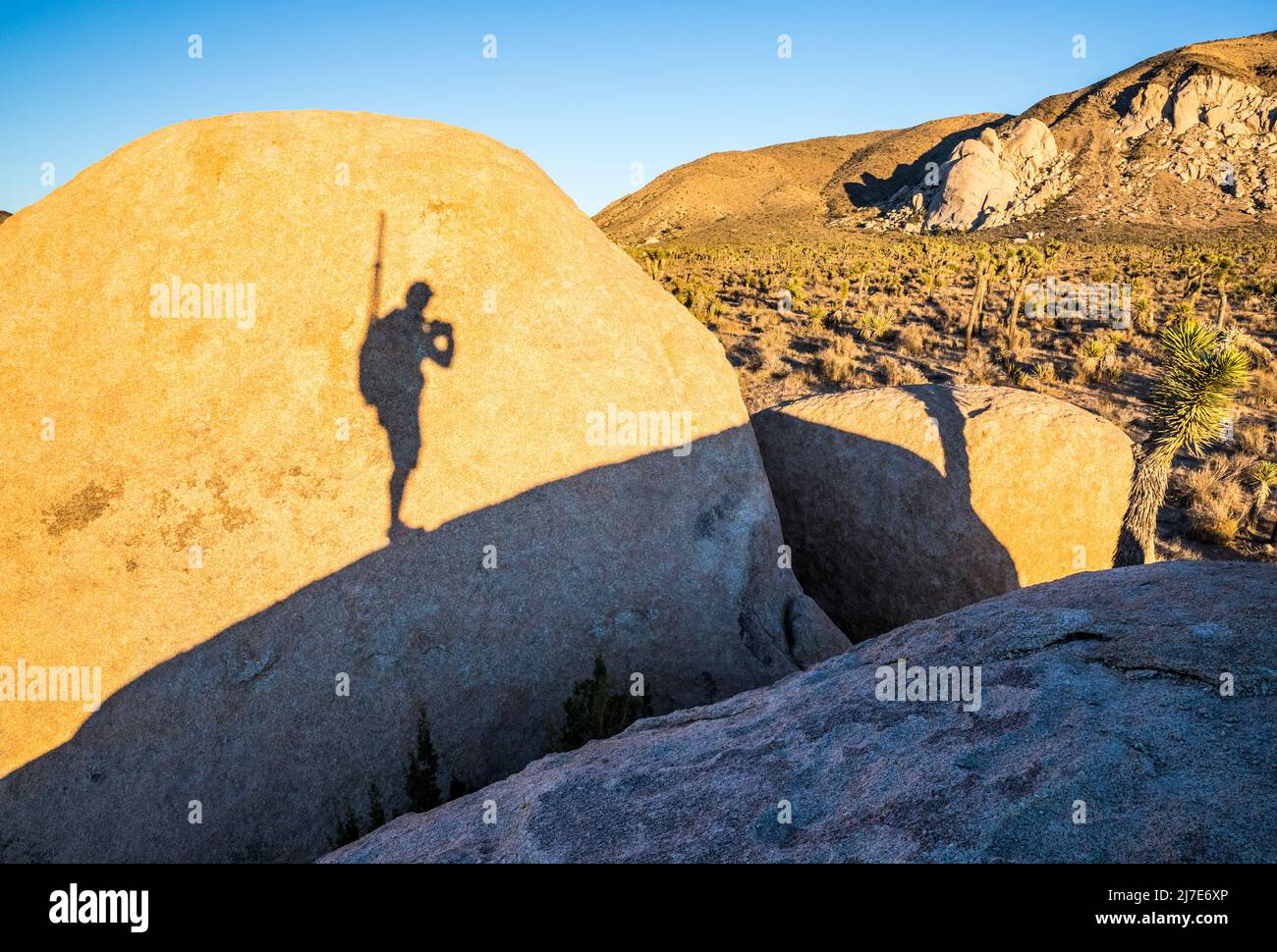 The shadow of a man cast on a boulder while he is taking a picture in ...