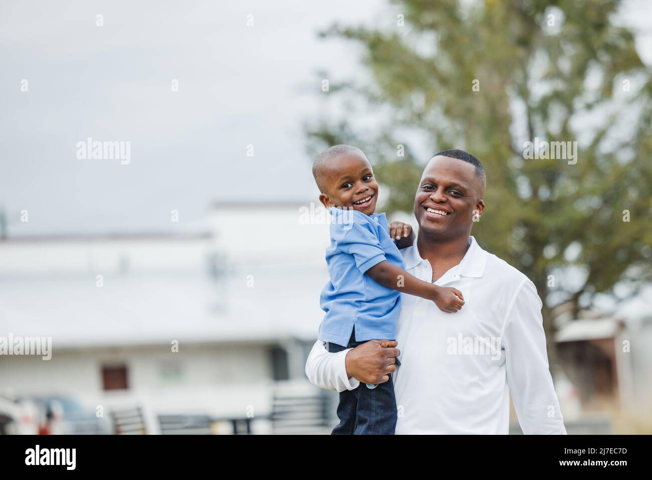 A young boy and his dad outdoors looking at the camera Stock Photo - Alamy