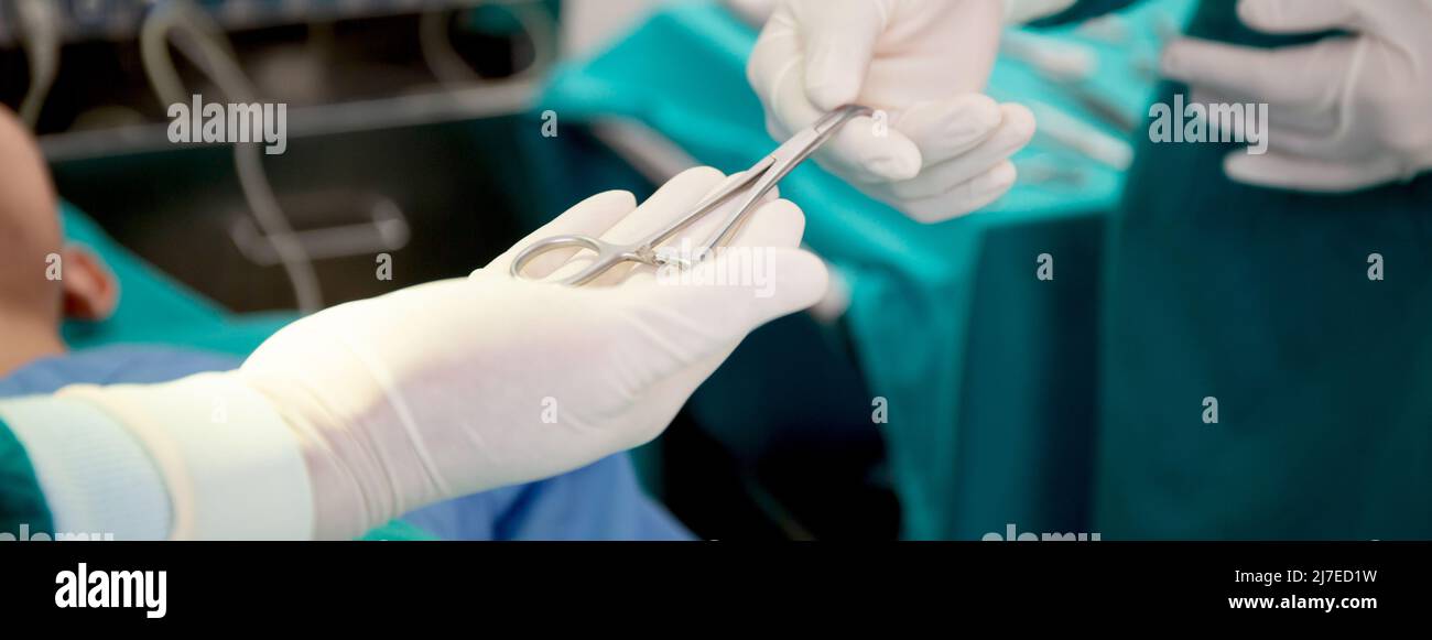 Closeup hands of doctor sending instrument with surgeon with rescue and ...