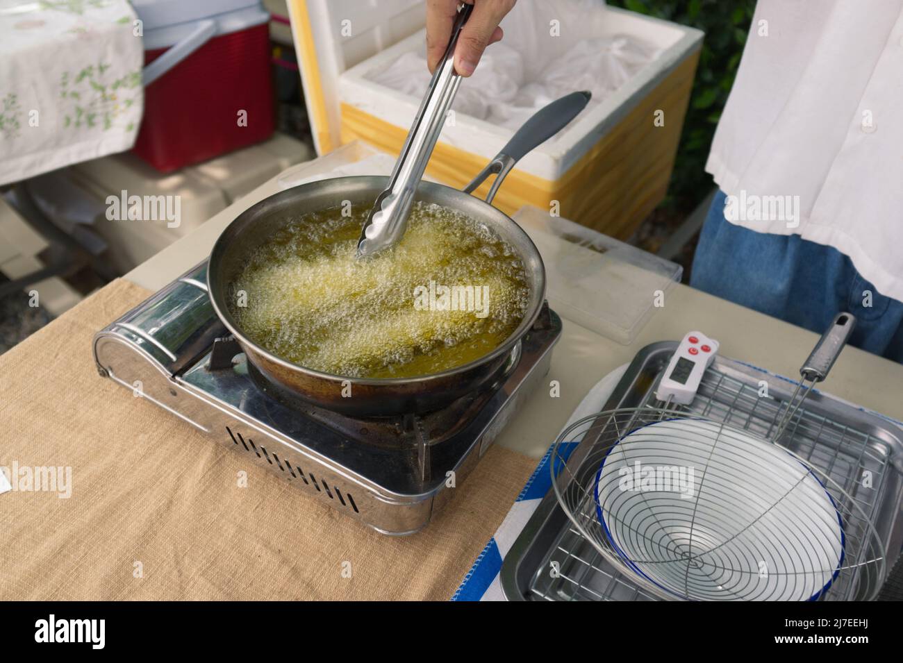 Churros are fried in boiling oil in a frying pan. concept COOKING ...