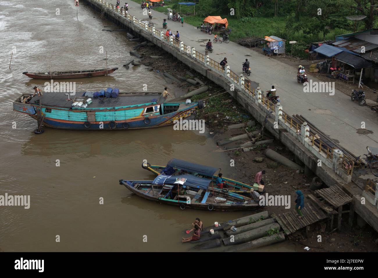 Boats, road traffic and people's activities on the bank of river Musi ...