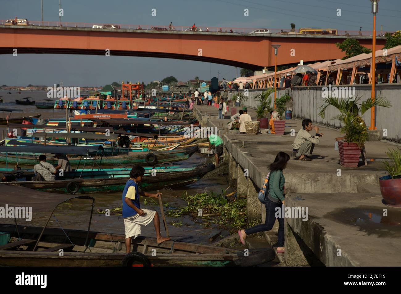 Boats on river Musi, in a background of Ampera bridge in Palembang ...