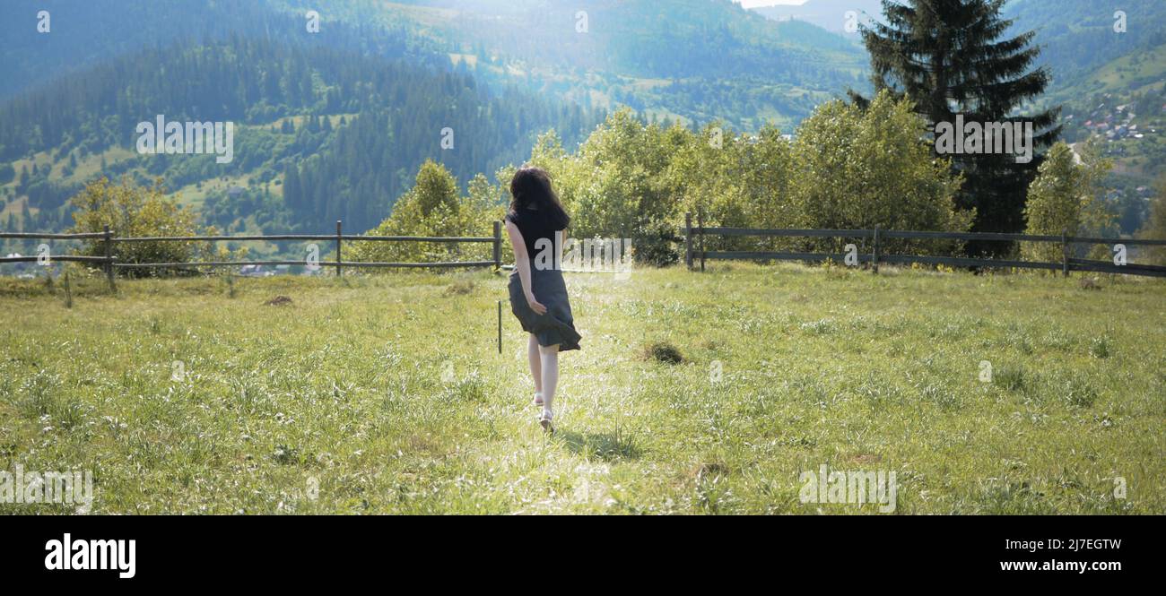 Happy young woman is running in the field. Freedom feeling in the ...