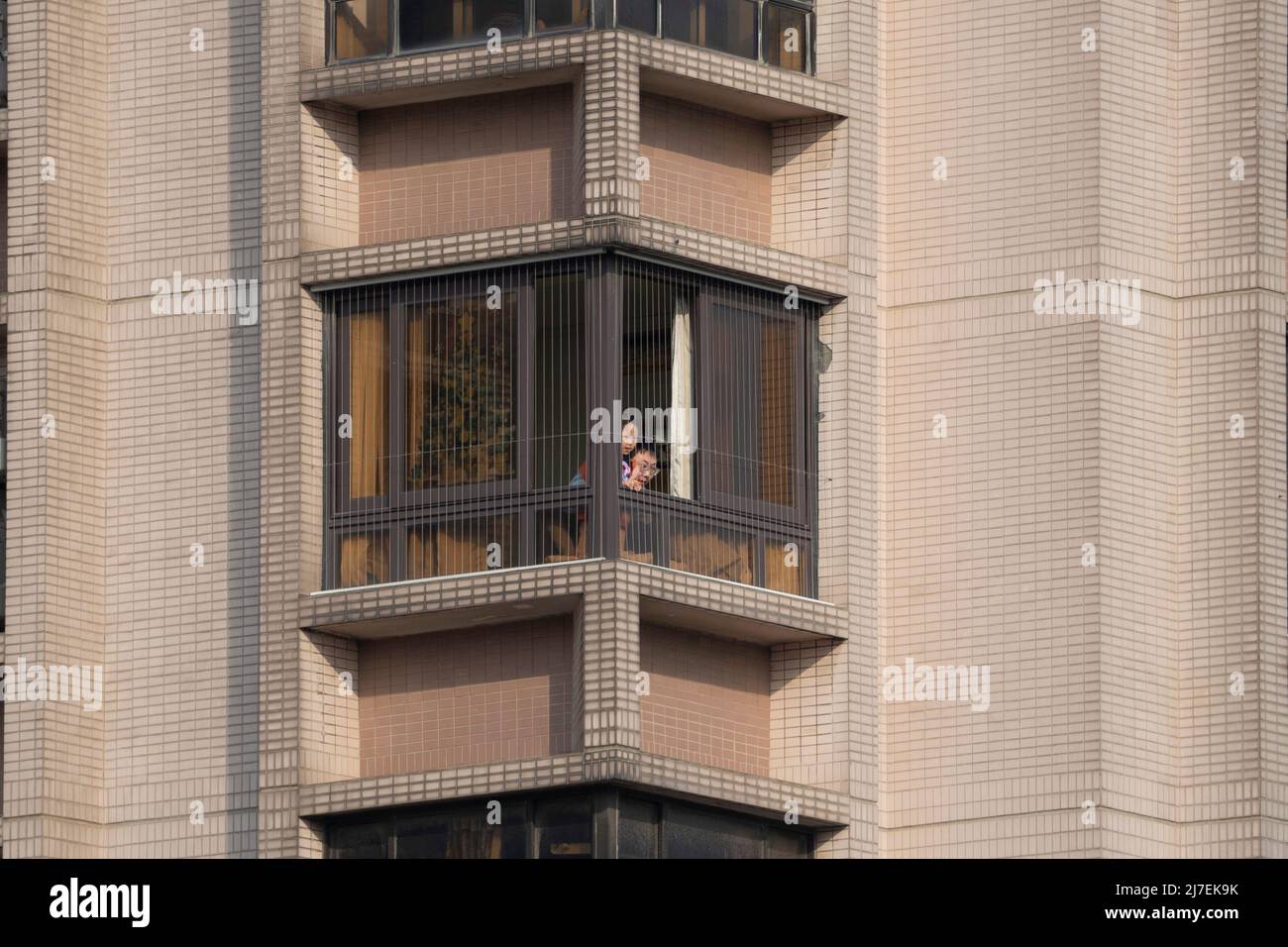 SHANGHAI, CHINA - MAY 2, 2022 - Residents look out the window of their ...