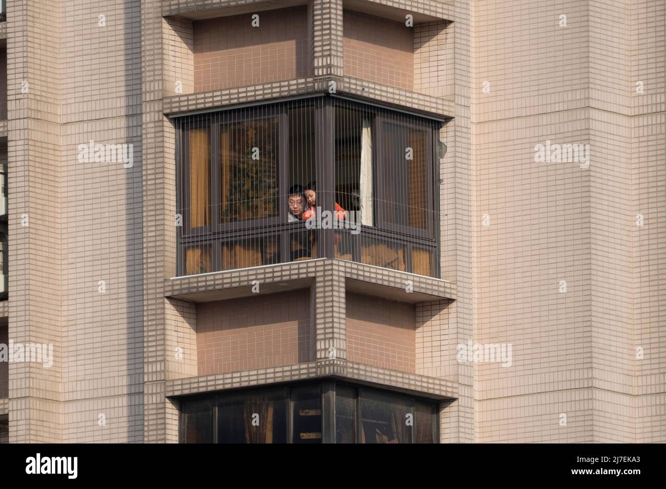 SHANGHAI, CHINA - MAY 2, 2022 - Residents look out the window of their ...