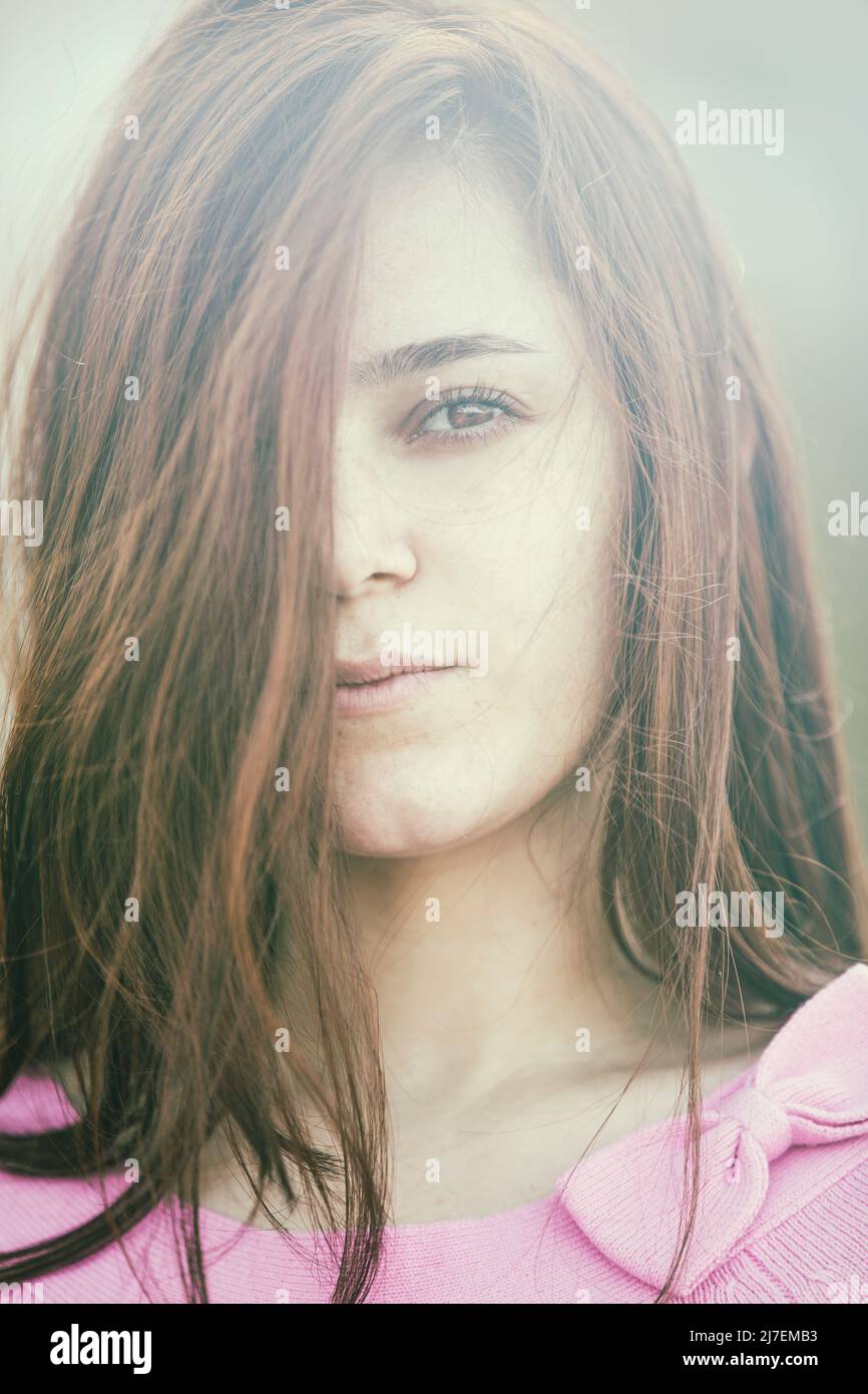 Beautiful woman hair covering face looking at camera Stock Photo - Alamy