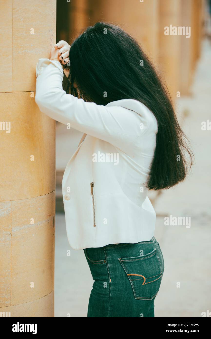 Sad woman leaning against the wall Stock Photo - Alamy