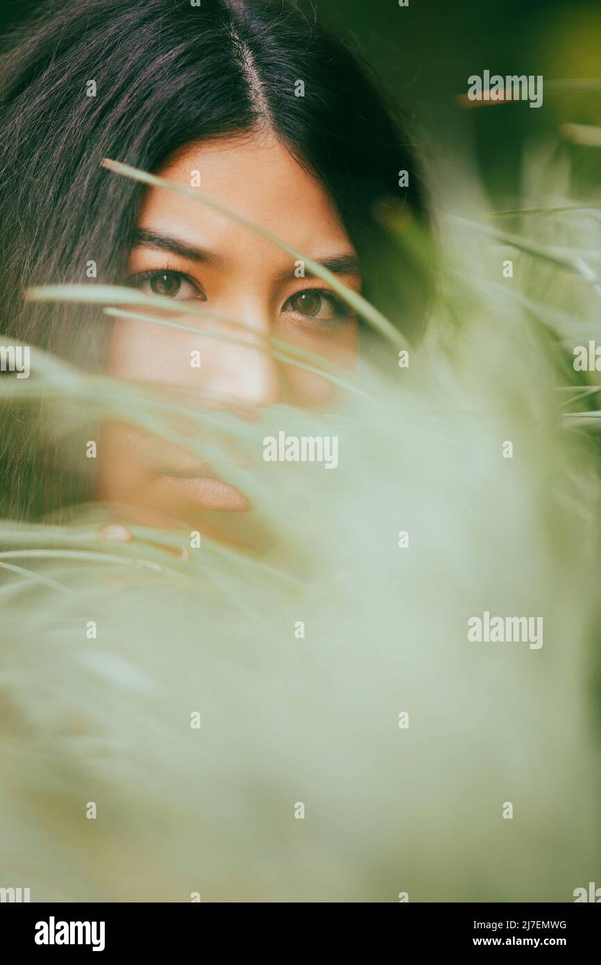 Scared woman peeking through the grass Stock Photo - Alamy
