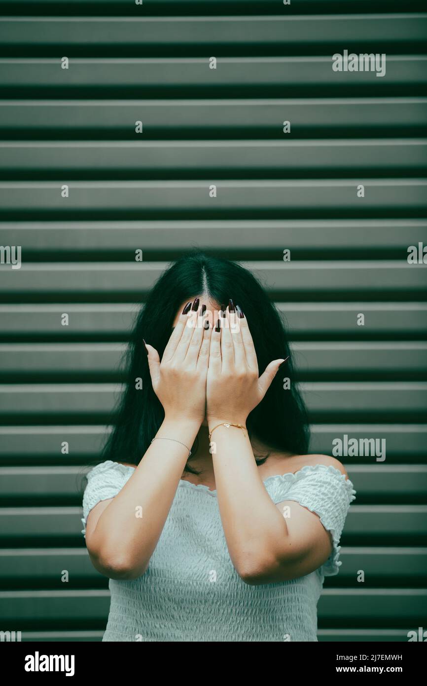 Woman hiding face with hands Stock Photo - Alamy