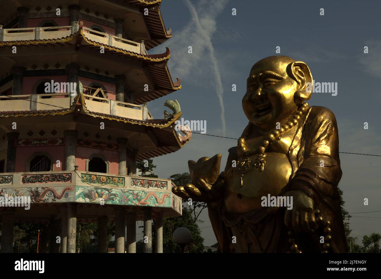 Statue of laughing Buddha in a background of the pagoda at Pulo Kemaro ...