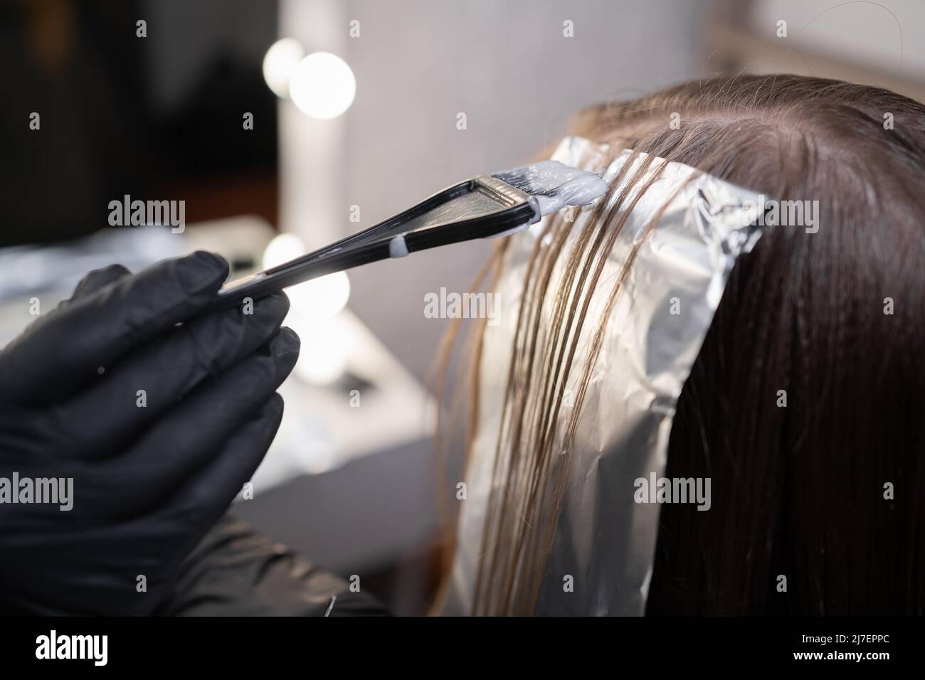 Close-up of a strand of female hair on a special sheet of foil, the ...