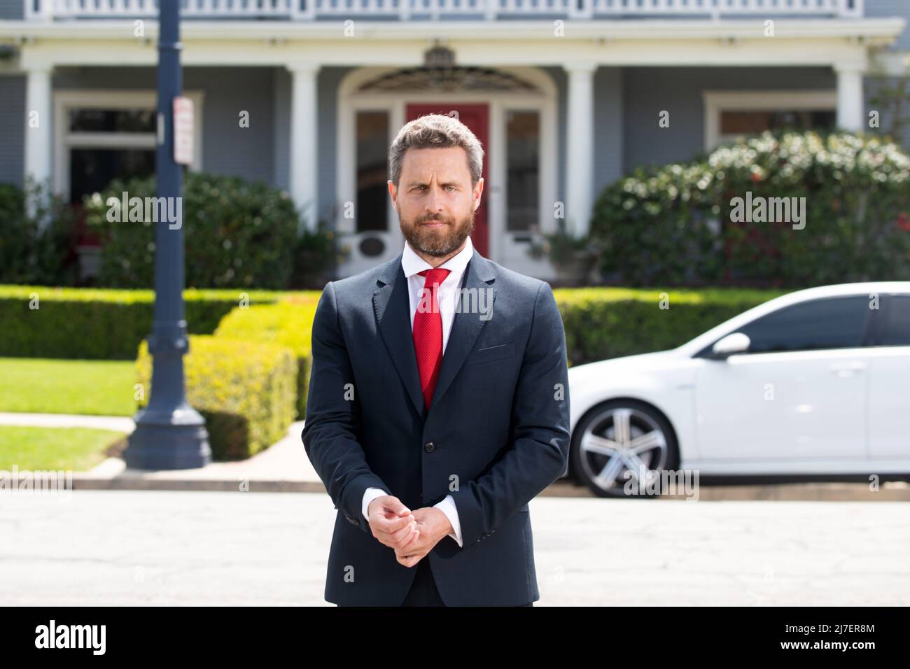 Real estate. Agent ready to sell home. Businessman standing outside a ...