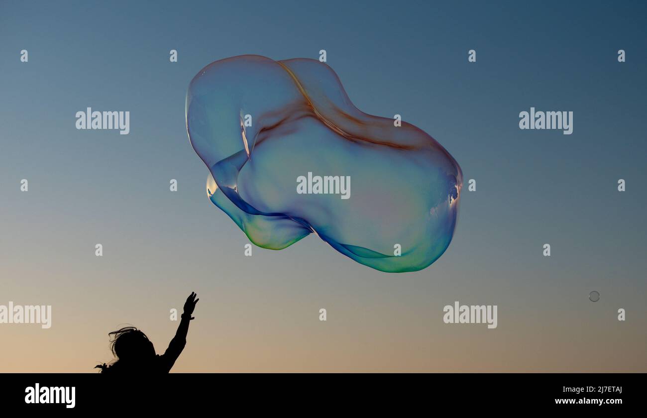 Soap bubbles. Hands trying to catch floating soap bubbles. Bubble show ...