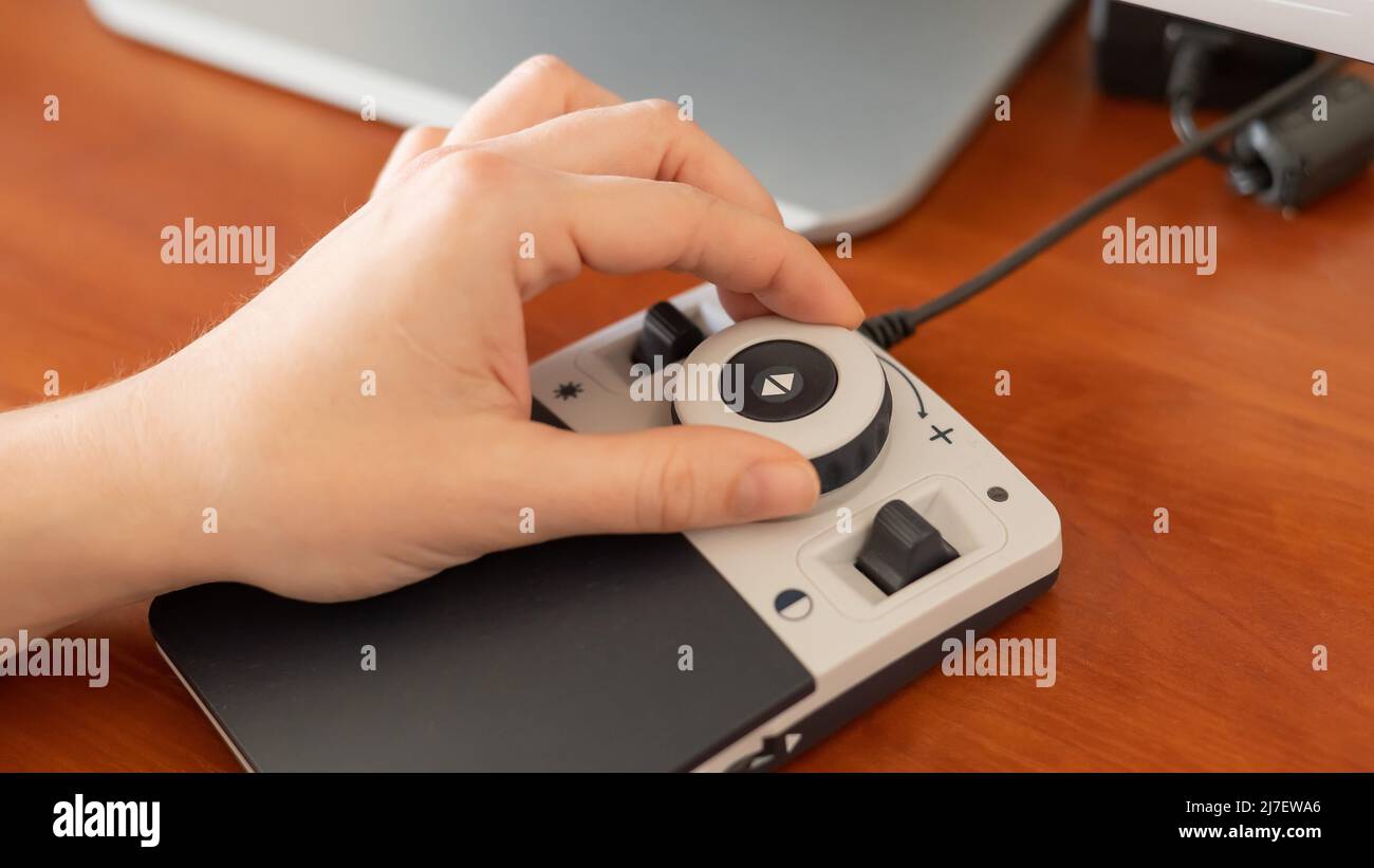 A woman uses a special magnification device for the visually impaired ...