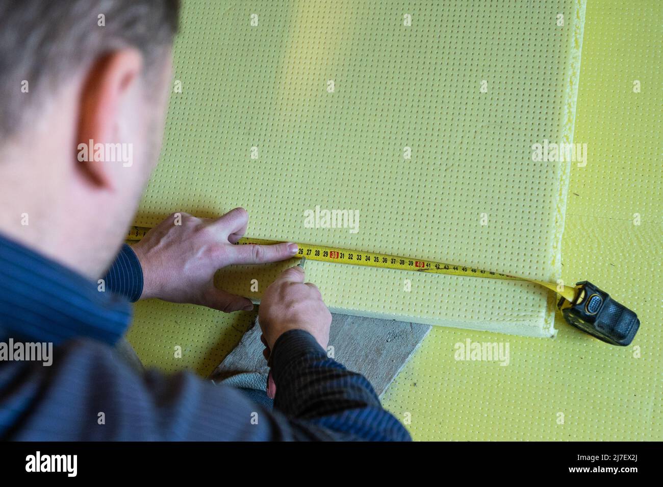 The master measures the length of expanded polystyrene on the floor ...