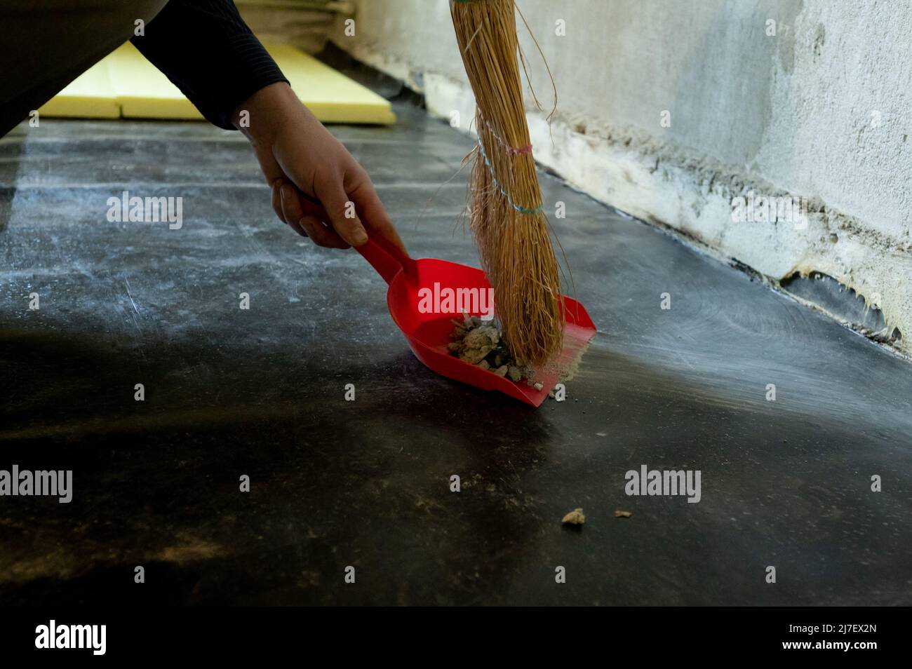A worker sweeps construction debris with a broom, gunpowder and small ...