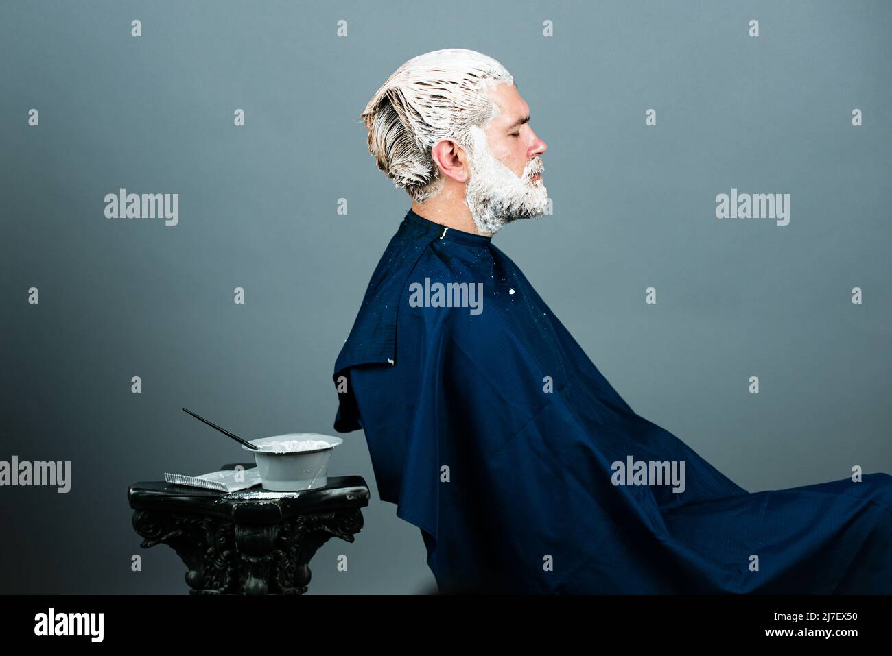 Barber shop. Portrait of bearded man color hair. Process of a man hair ...