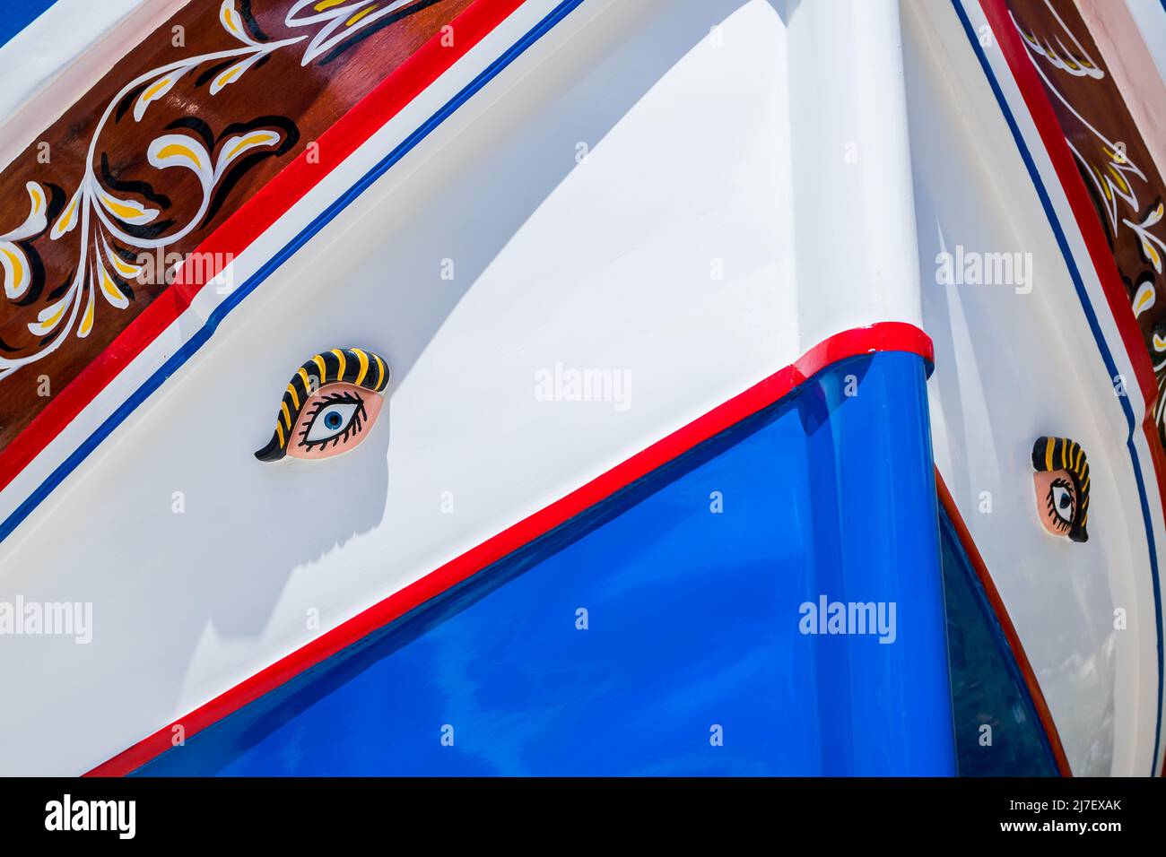 Brightly coloured Luzzu boat seen on the edge of the water in Bugibba ...