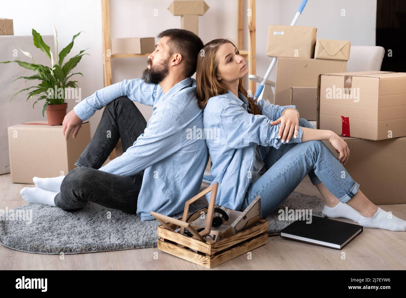 a tired couple in love, a man and a woman, on the day of the move, sit ...