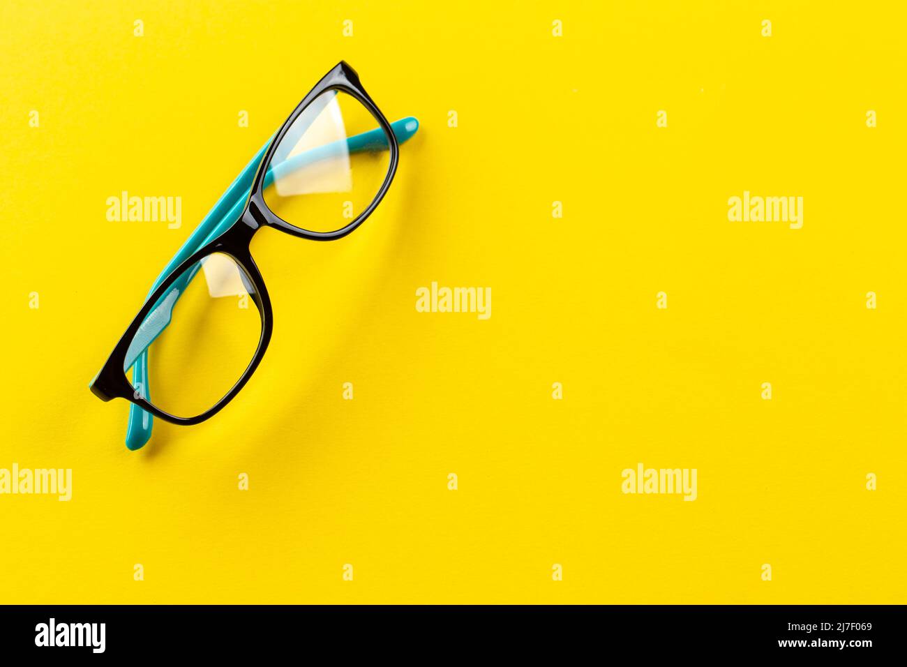 Stylish eyeglasses over yellow background. Glasses selection, eye test ...