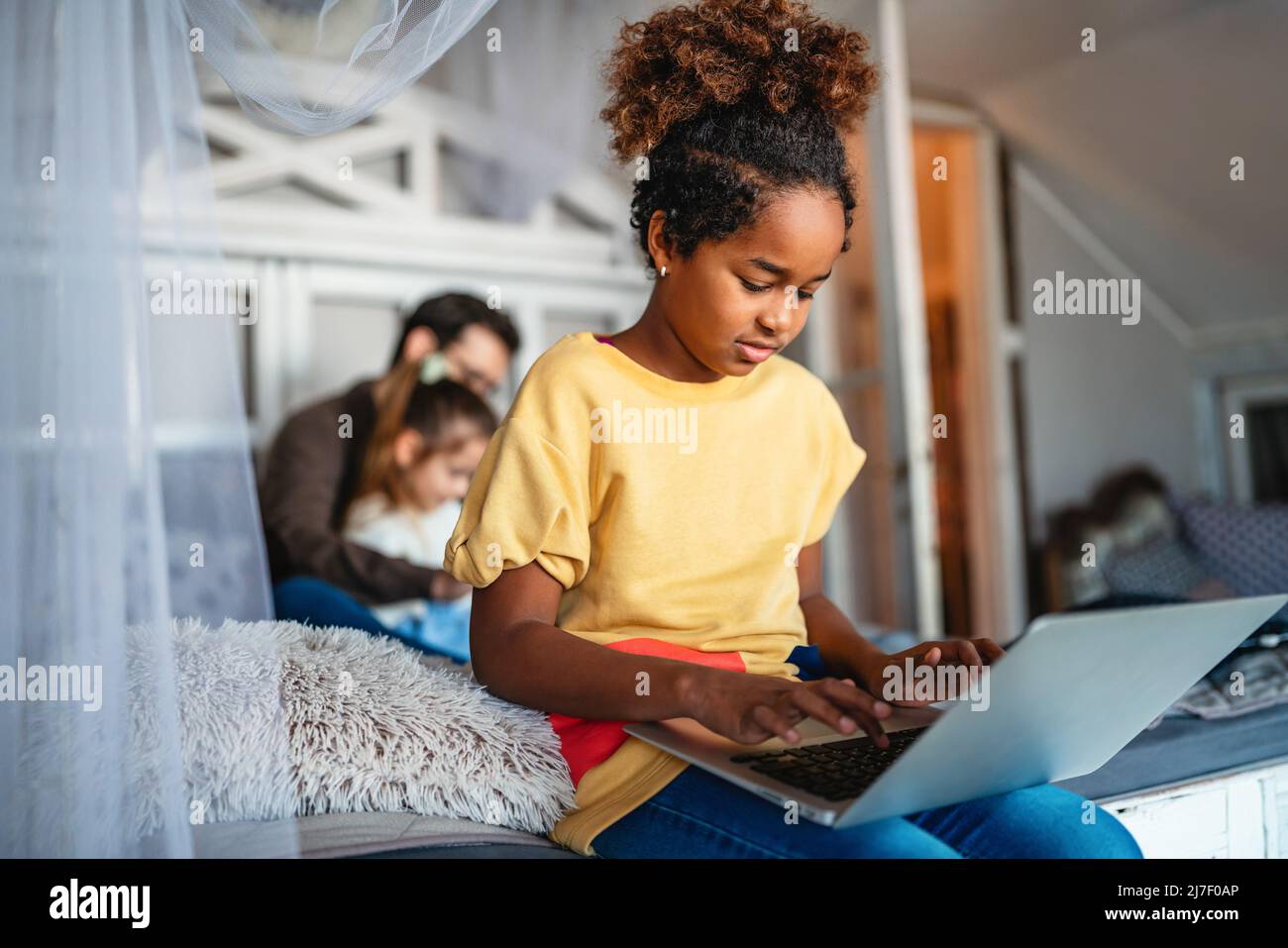 Happy black child girl studying online on computer at home Stock Photo ...