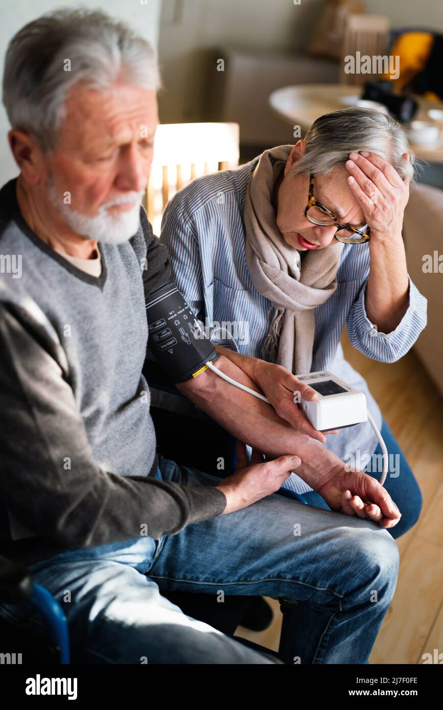 Senior couple at home measuring blood pressure. Home monitoring people ...